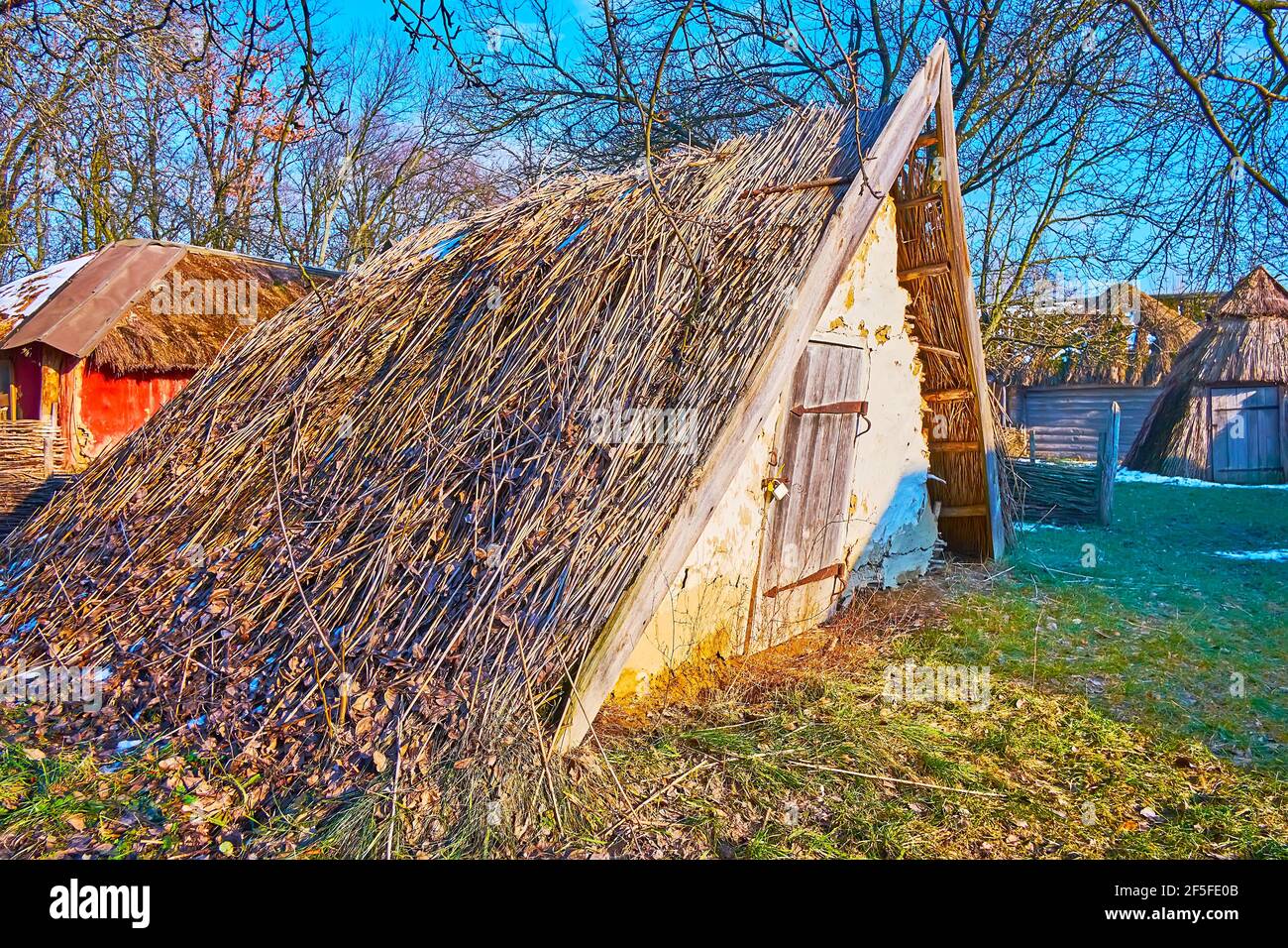 The leaning clay building of the root cellar with straw roof, Pyrohiv ...