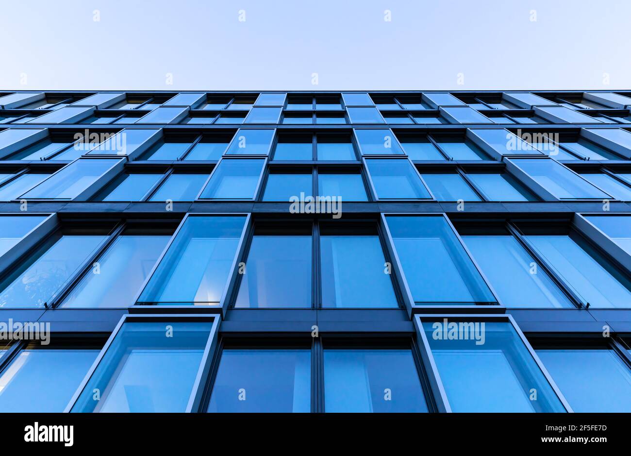 Blue tinted low angle close-up of modern downtown headquarter office ...