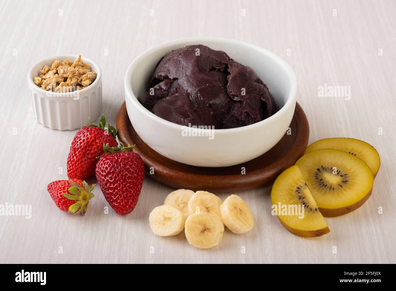 Brazilian typical acai bowl with fruits and muesli over wooden ...