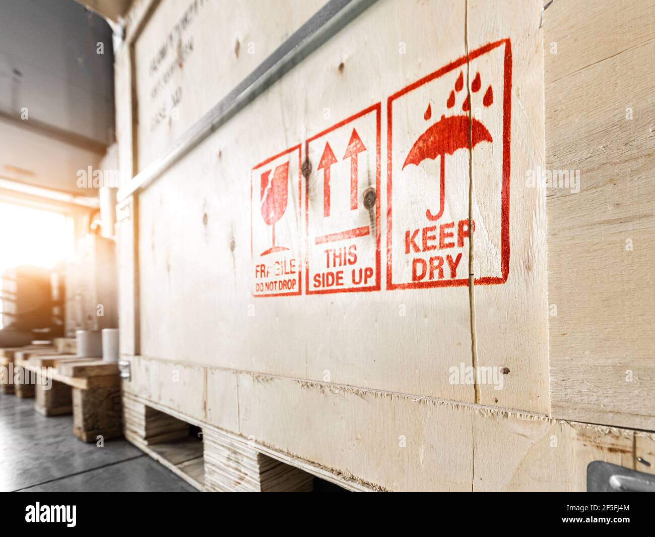 Bright red special marking symbols on wooden boxes with goods inside ...