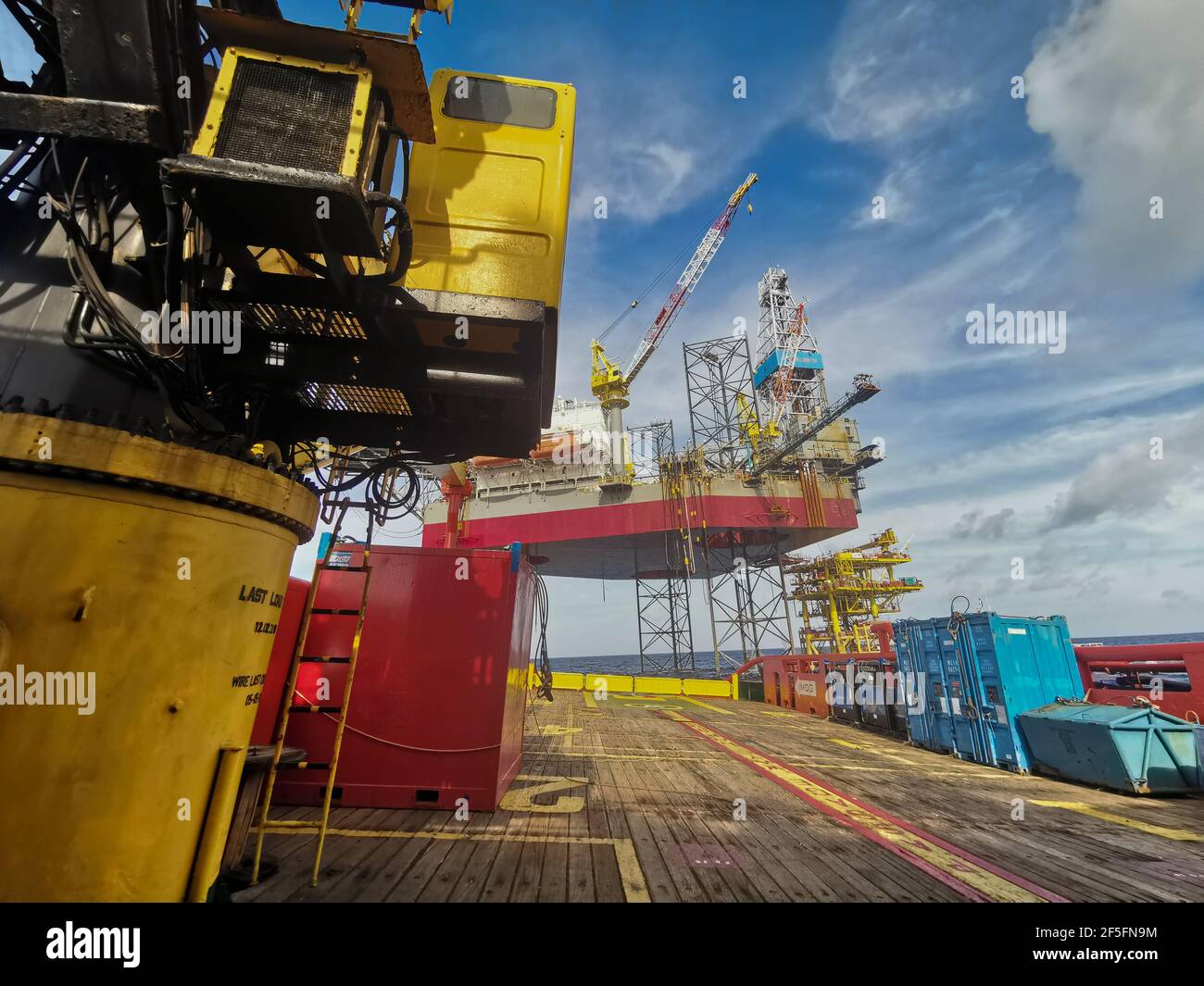 offshore supply vessel slowly approaching to oil rig during 500 meter ...