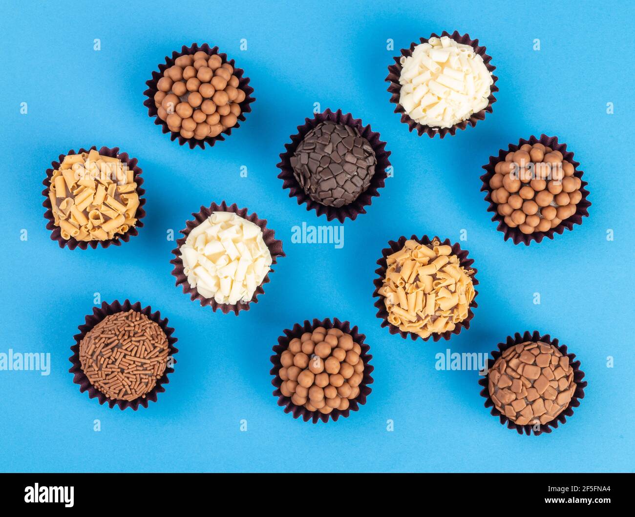 Typical brazilian brigadeiros, various flavors over colorful background ...