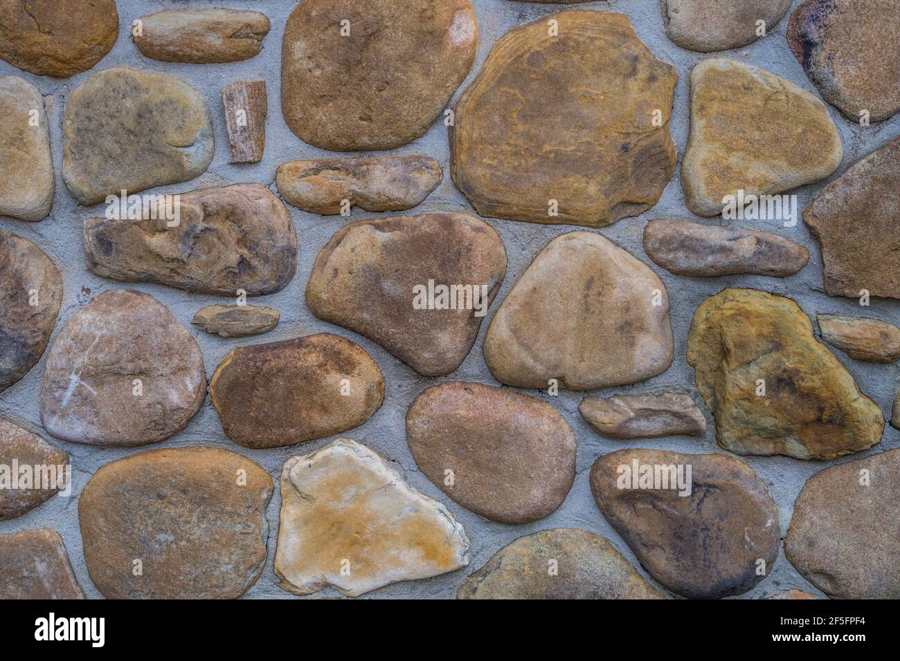 Variety of river rocks made into a exterior wall on a building ...
