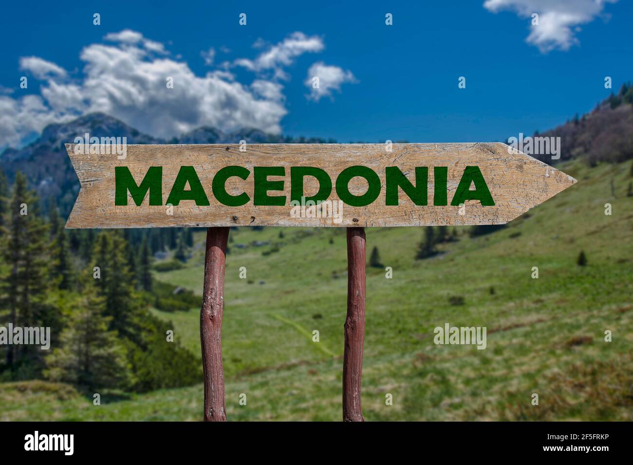 Macedonia wooden arrow road sign against mountain valley background ...