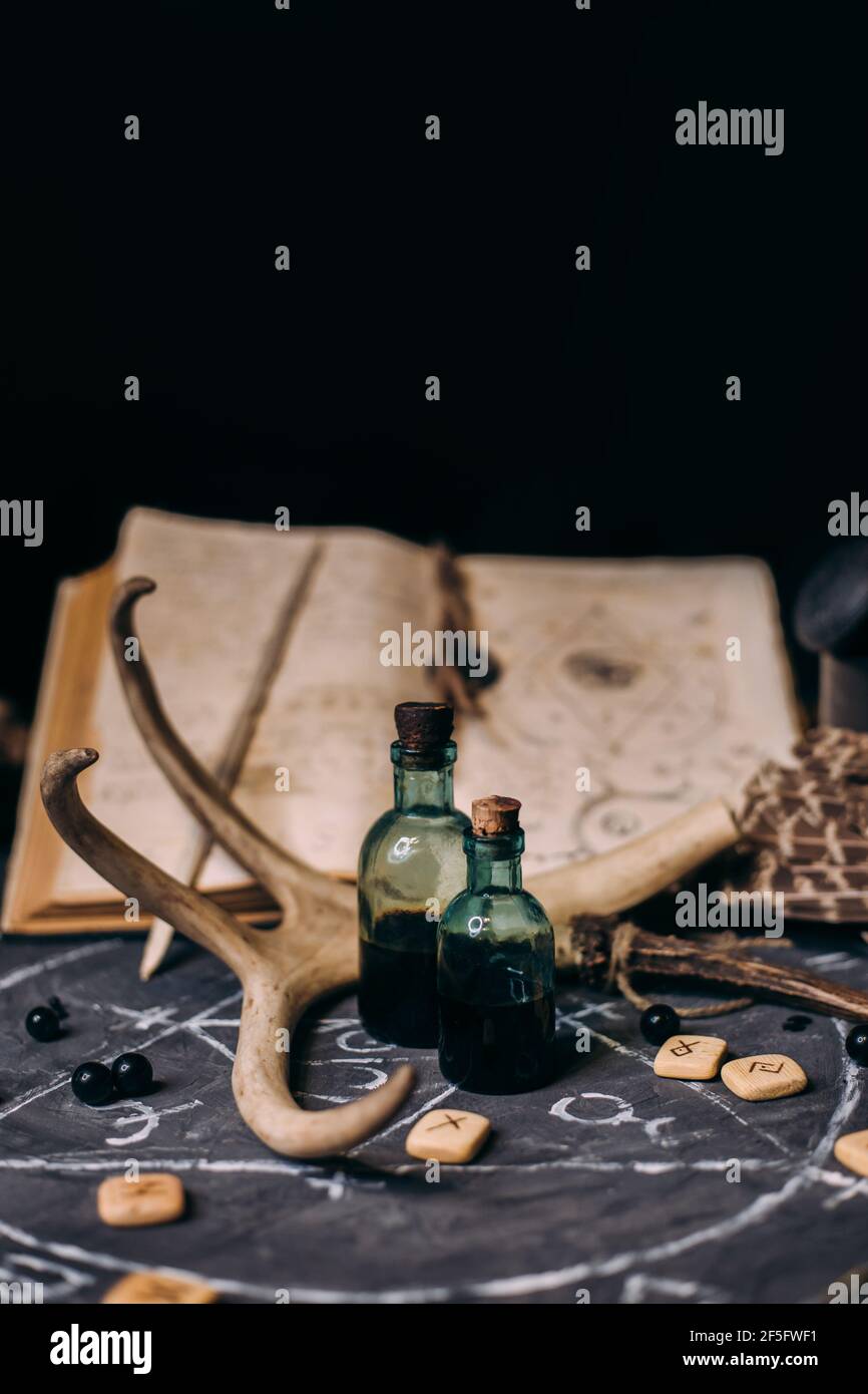 Magic potion bottle. Modern witchcraft concept with potions, herbs and ...