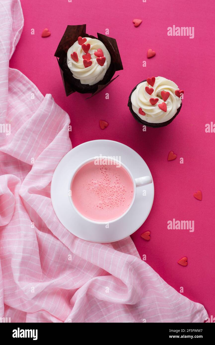 Cupcake decorated with hearts on pink background and cup with pink ...