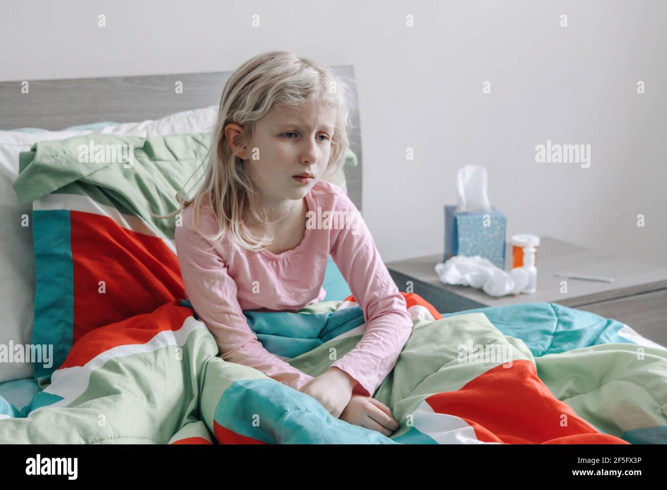 Sick ill Caucasian girl with fever lying in bed at home. Virus cold ...
