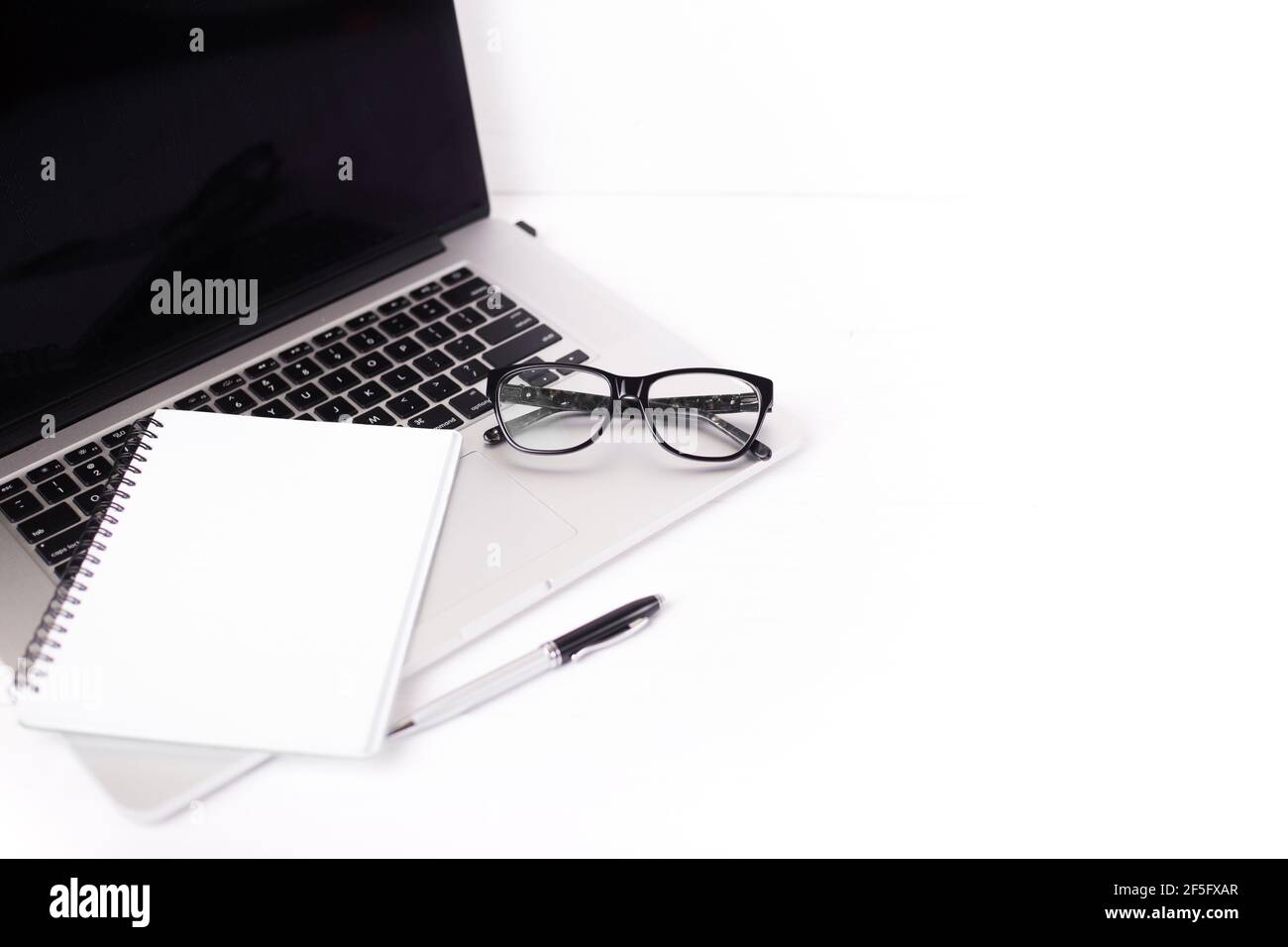 PComputer, blank notebook, pen and glasses. Home office and career ...