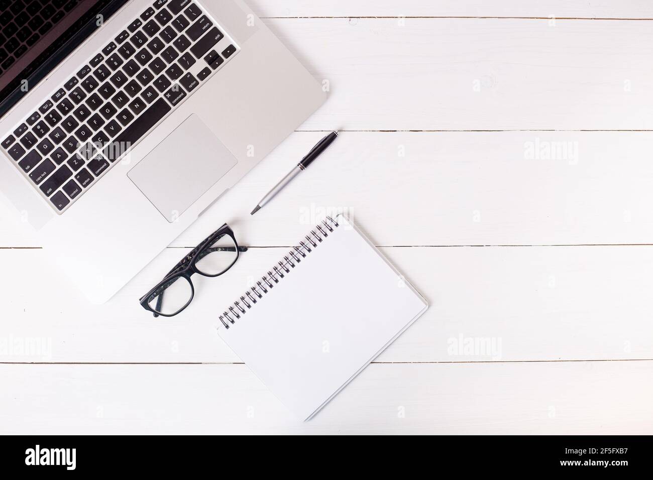 PComputer, blank notebook, pen and glasses. Home office and career ...