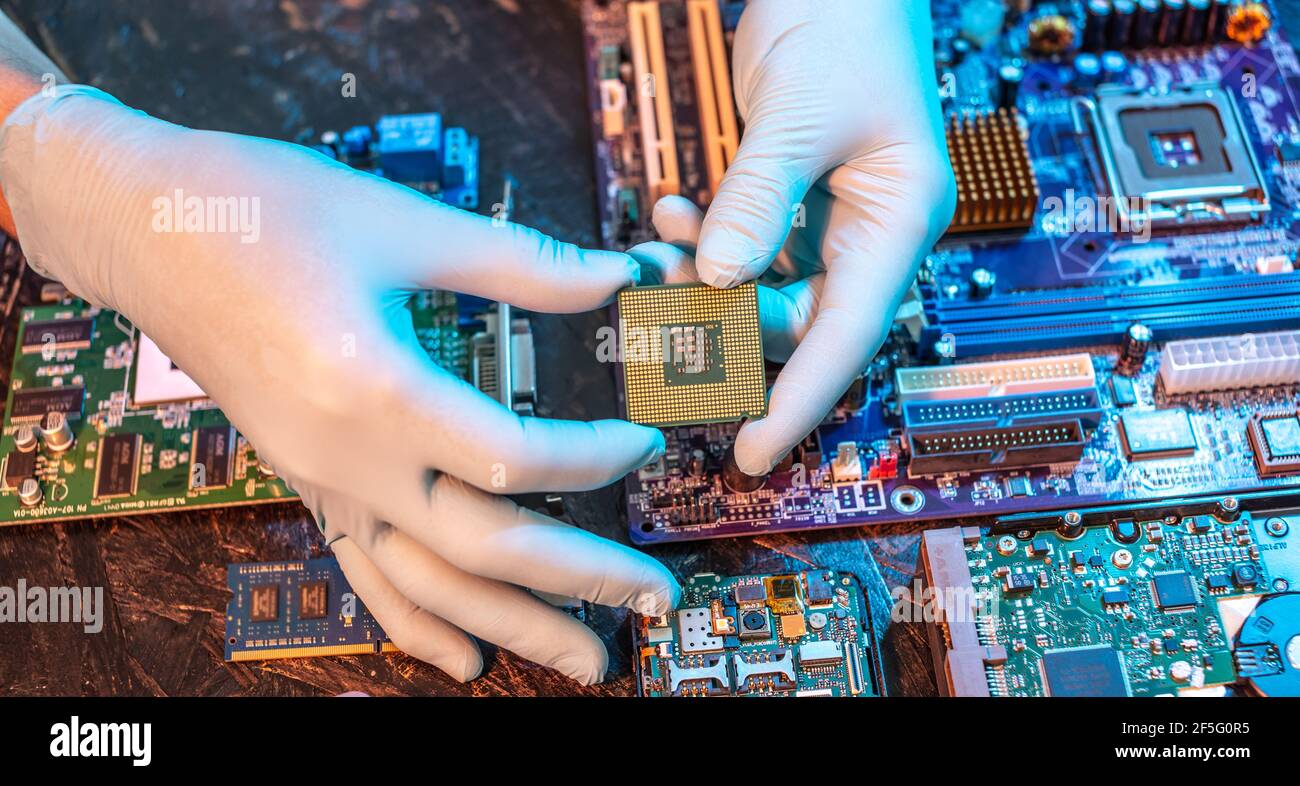 The engineer's gloved hand is holding the CPU chip against the ...
