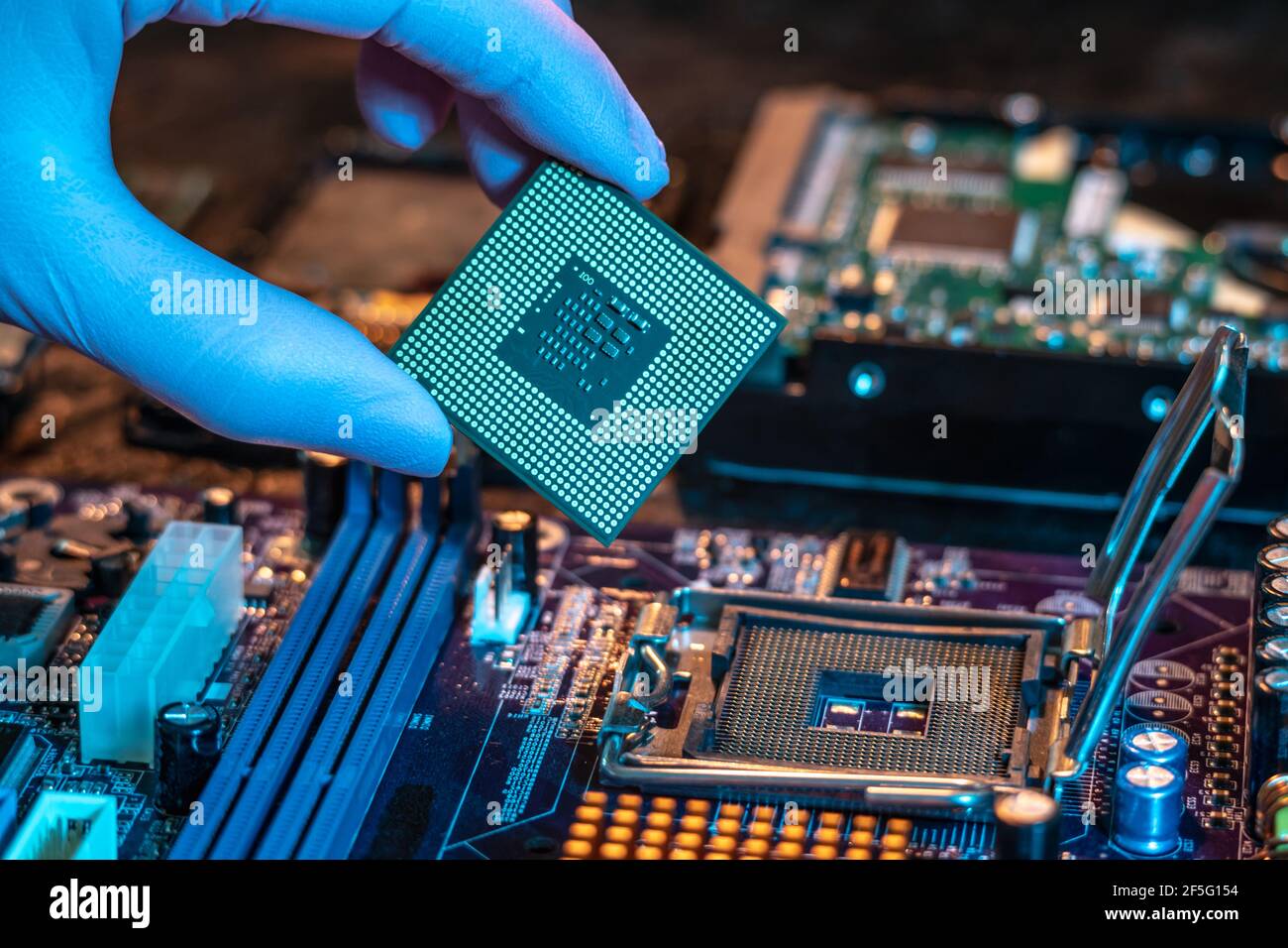 The engineer's gloved hand is holding the CPU chip against the ...