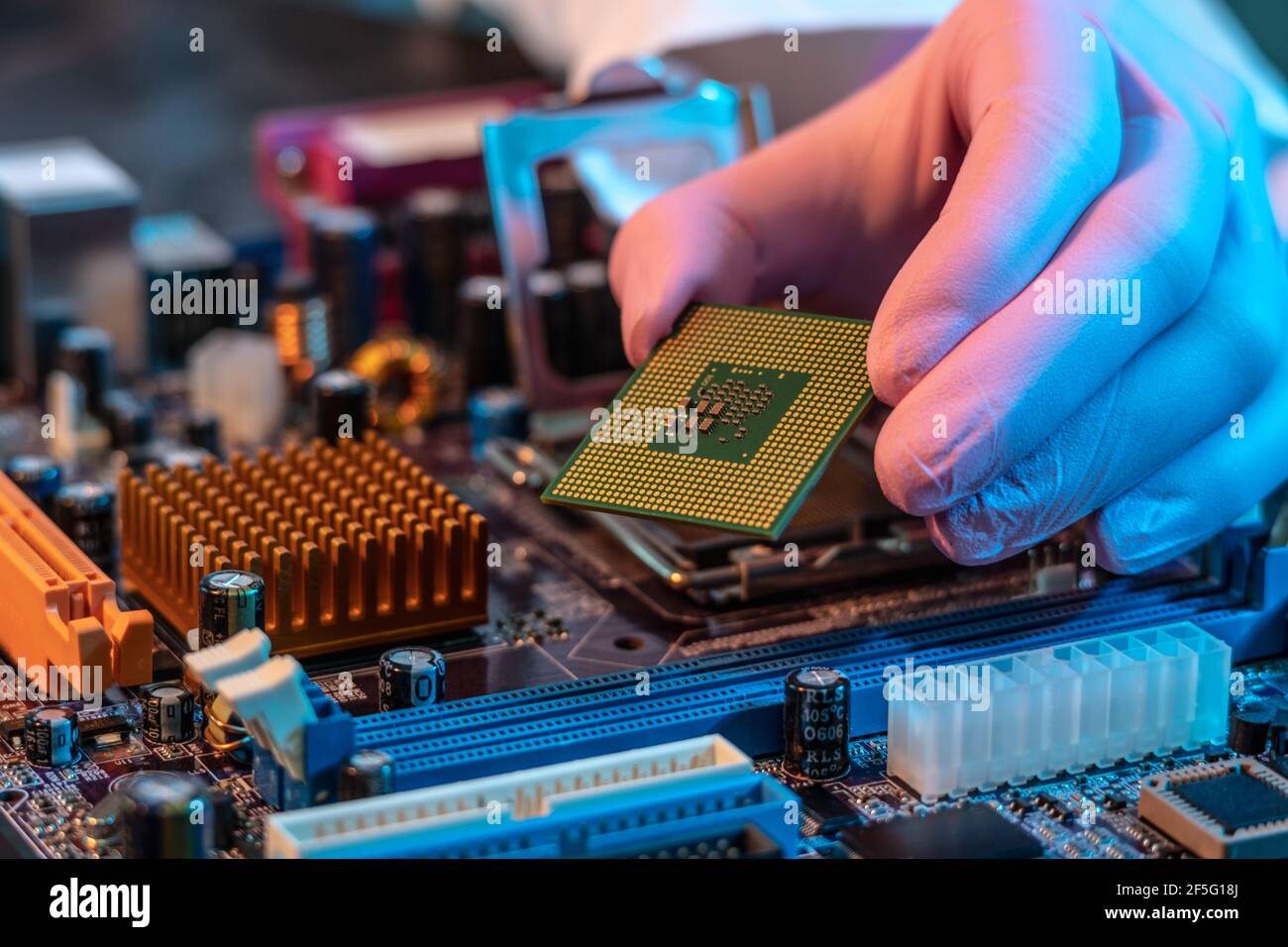 The engineer's gloved hand is holding the CPU chip against the ...