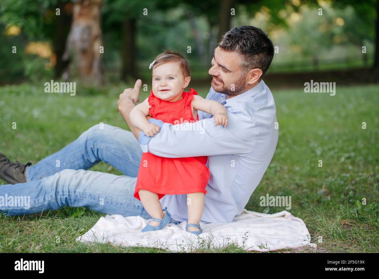 Fathers Day. Middle age Caucasian proud father playing with baby ...