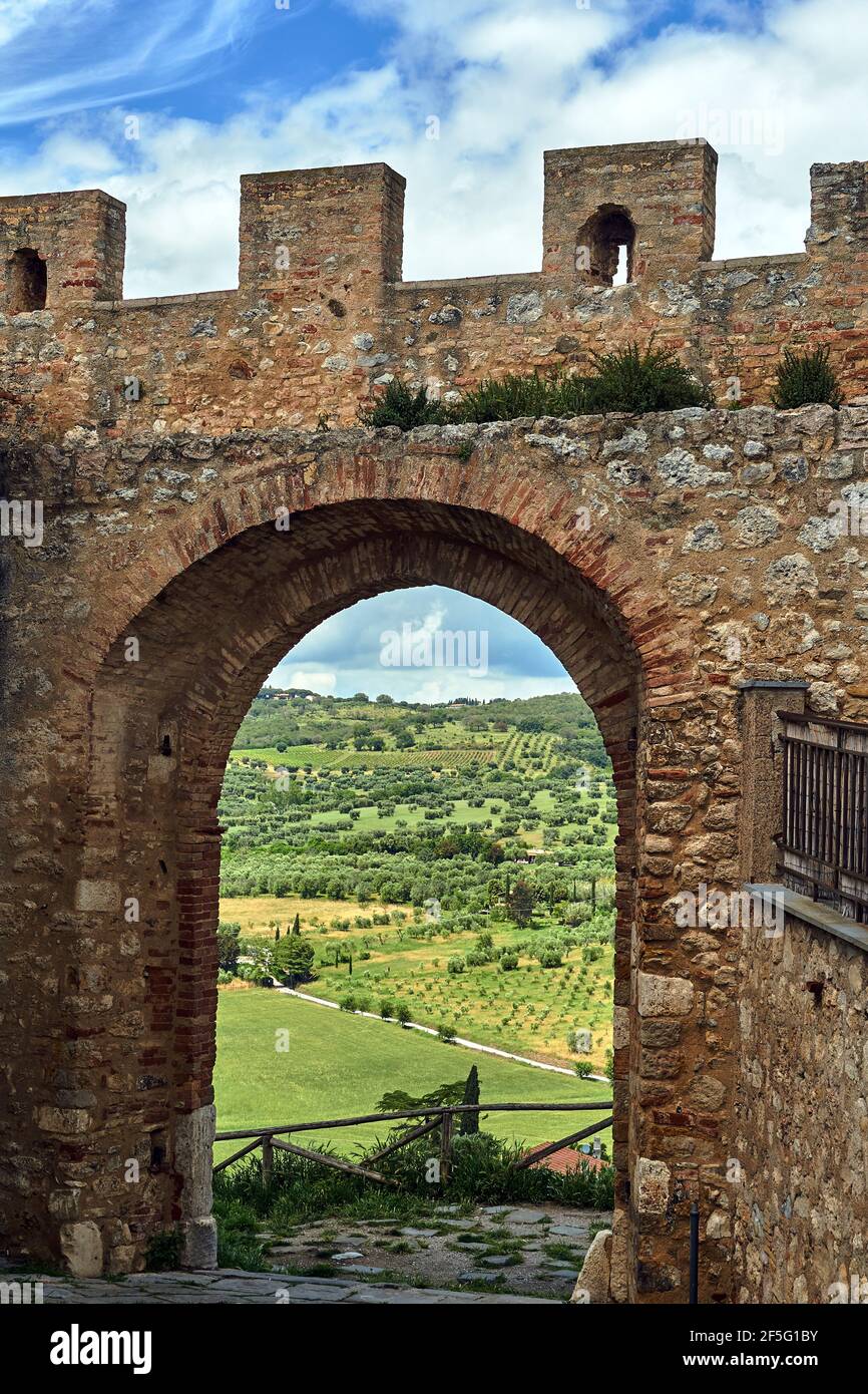 Medieval defensive wall with a gate and rural landscape with olive ...