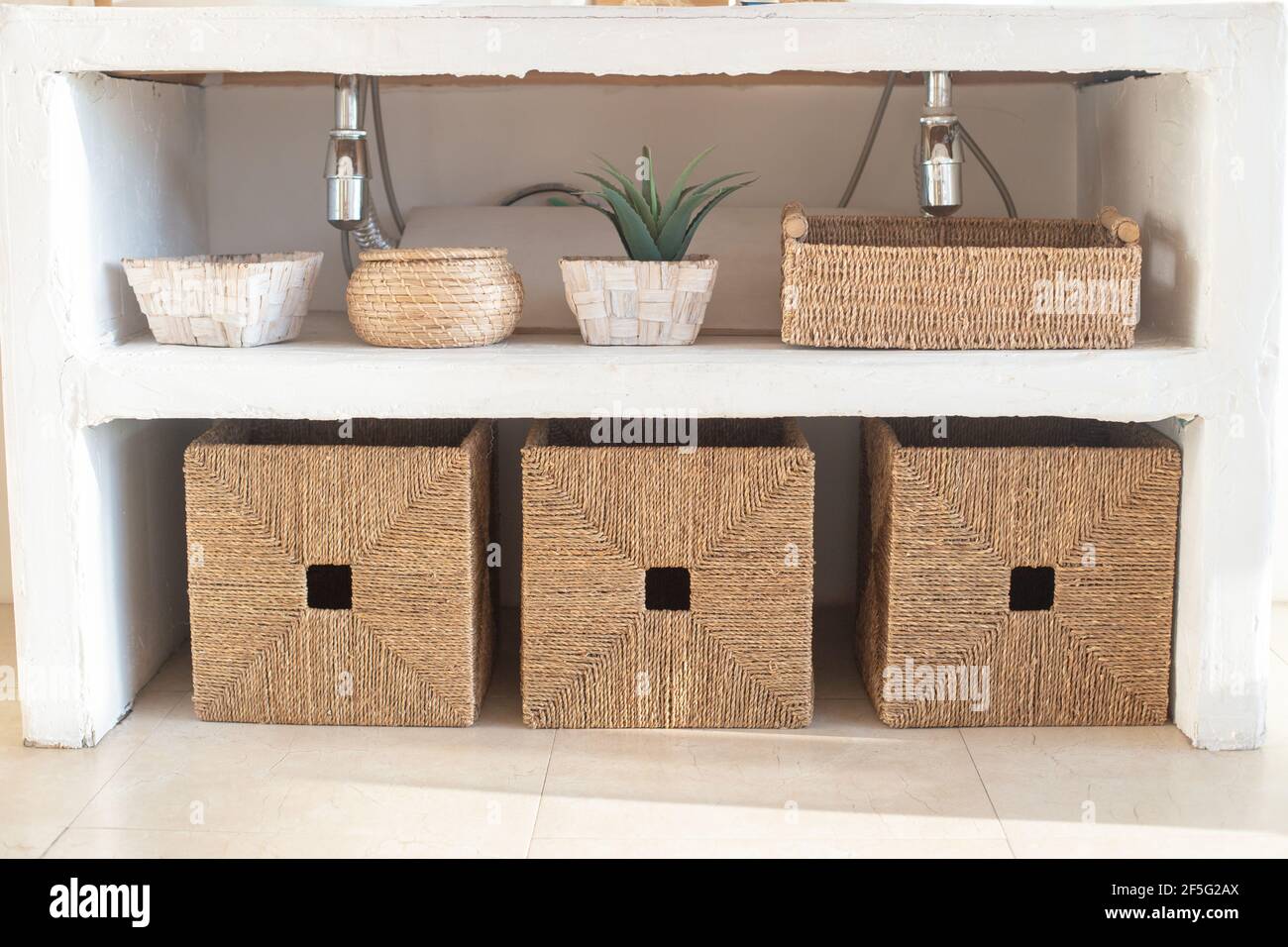 Details of modern cozy white interior with wicker boxes Stock Photo - Alamy