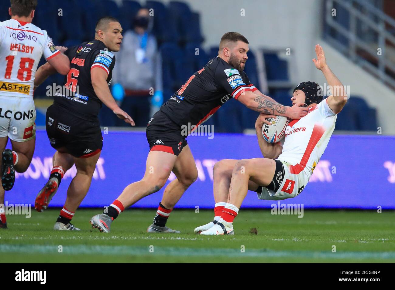Ryan Lannon (11) of Salford Red Devils is tackled by Jonny Lomax (6) of ...