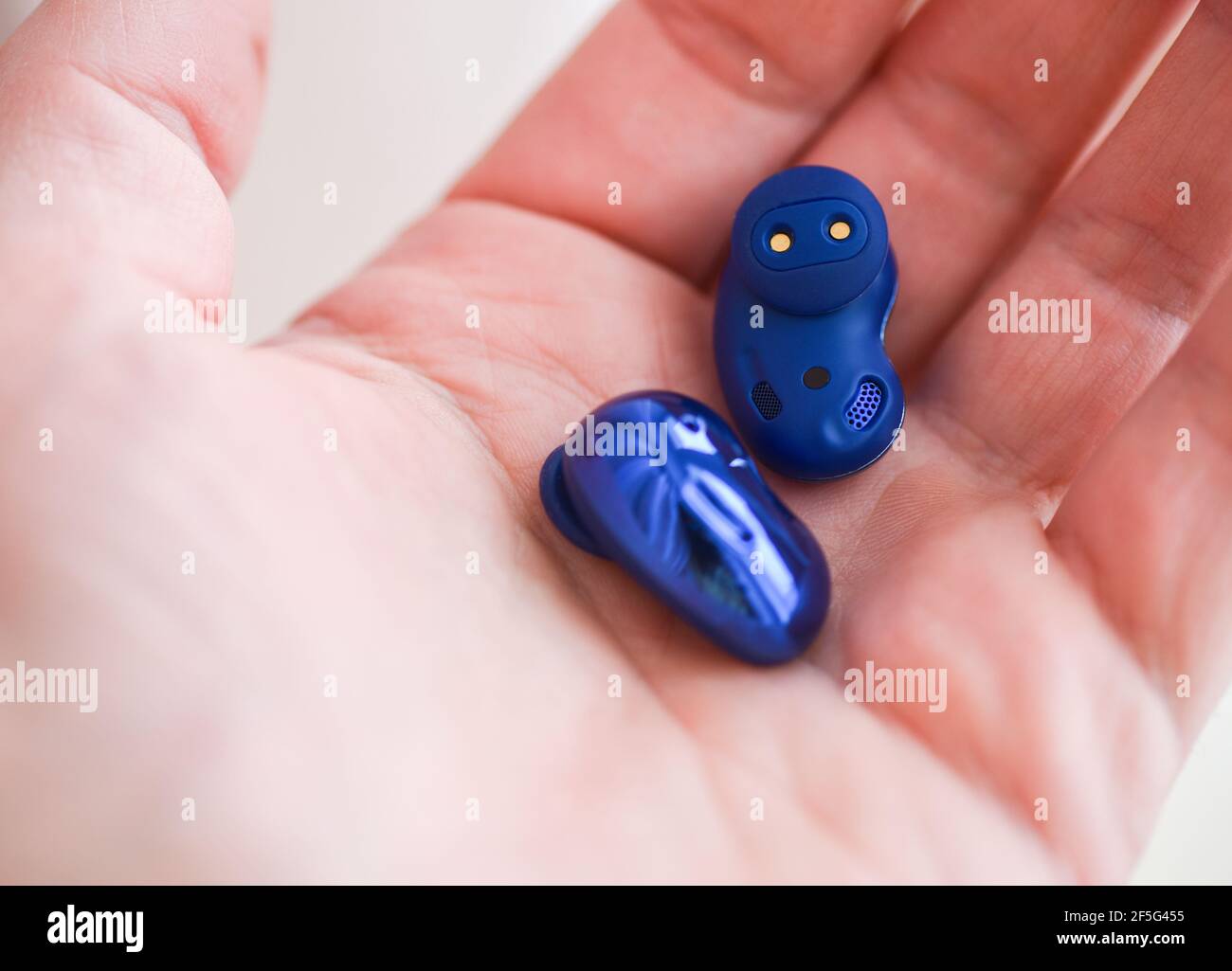 Blue wireless earbuds earbuds in hand on white background Stock Photo ...