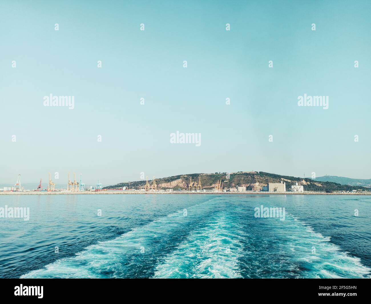 Wave wake from sailing ship with Port and Ropeway of Barcelona, Spain ...