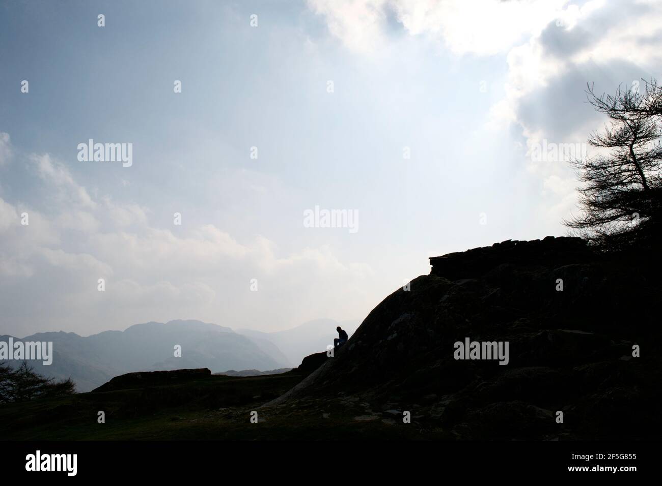 Dark, brooding, dramatic: silhouette of an anonymous figure sat on a ...