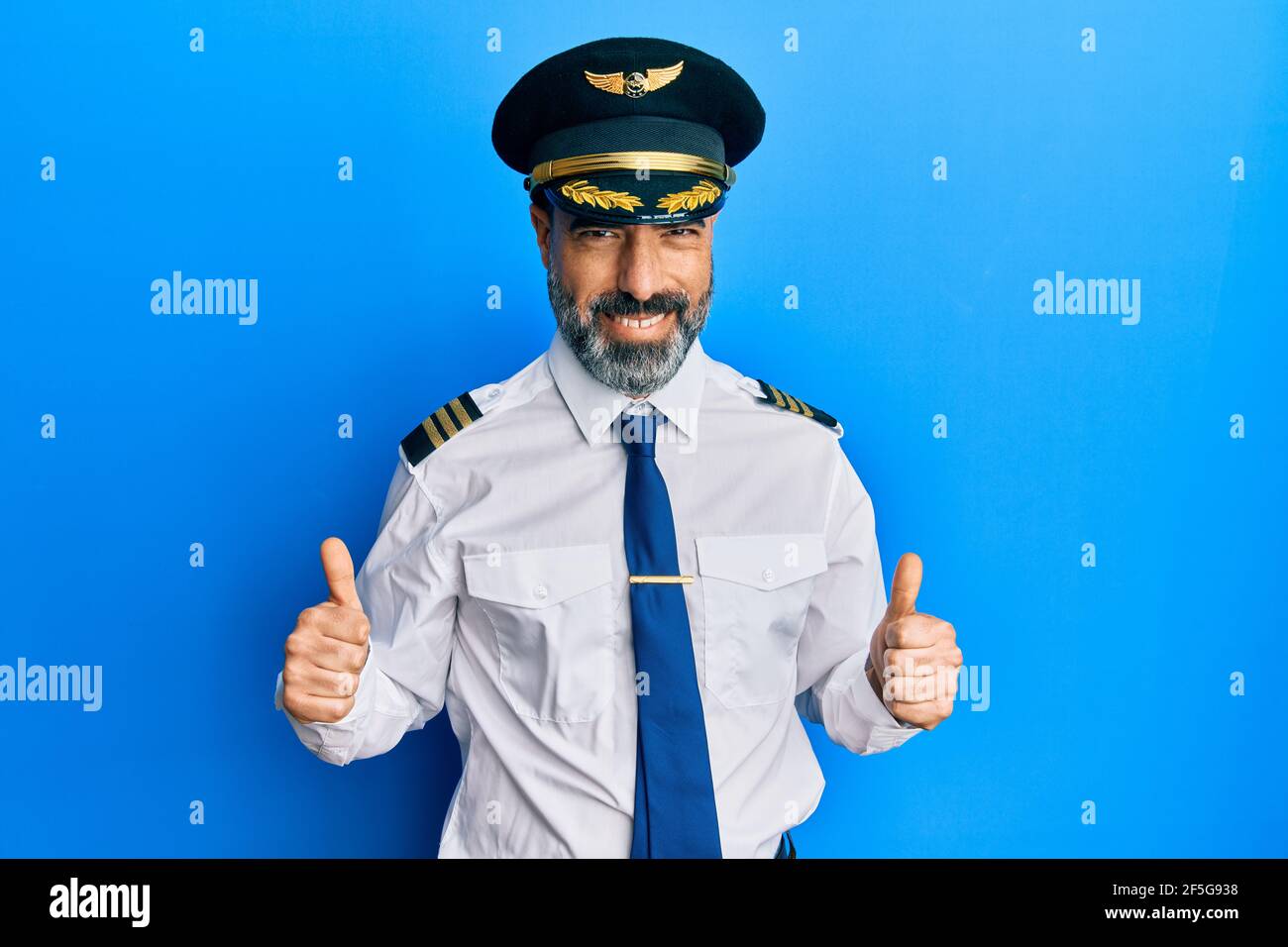 Middle age man with beard and grey hair wearing airplane pilot uniform ...