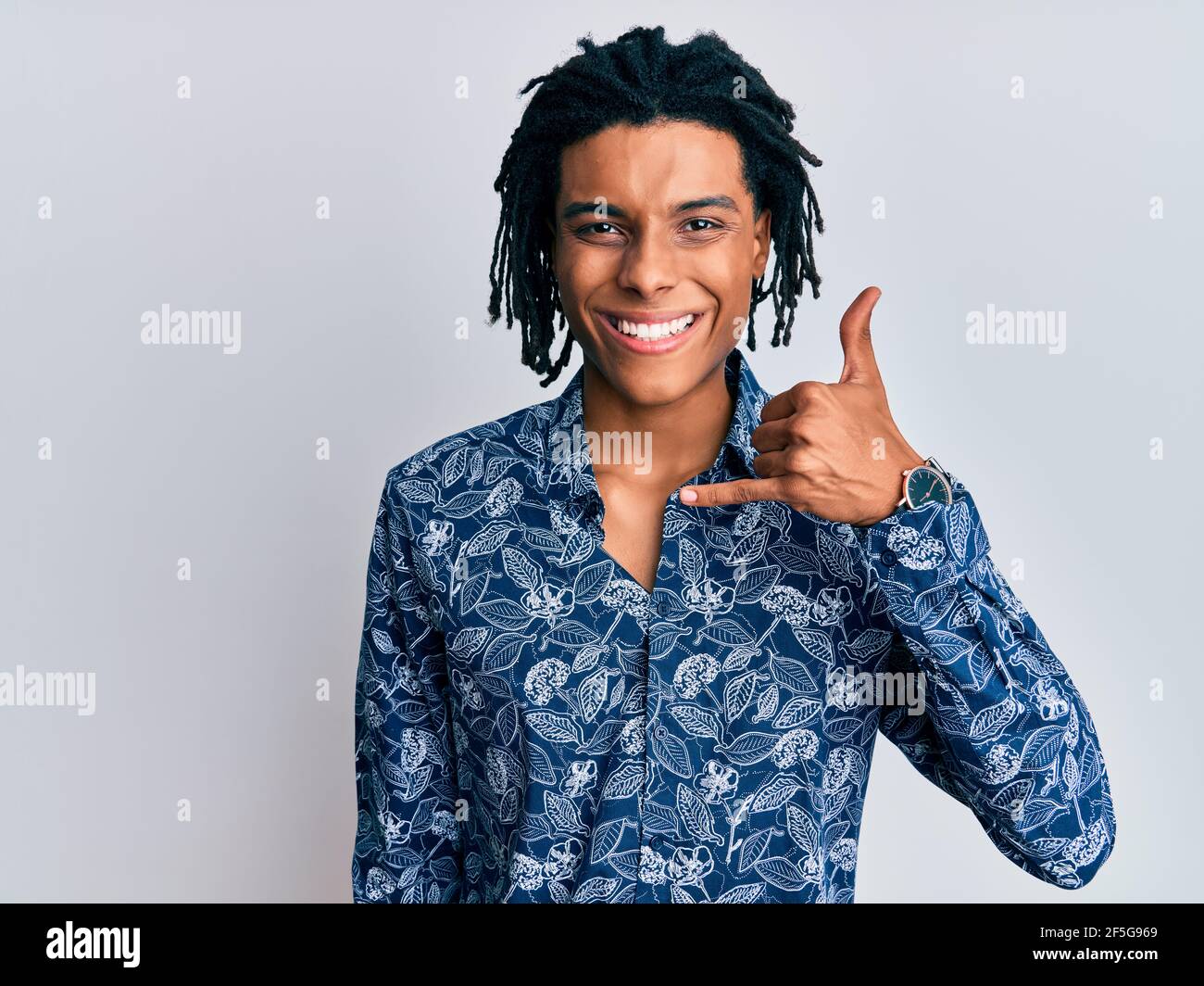 Young african american man wearing 80s style shirt smiling doing phone ...