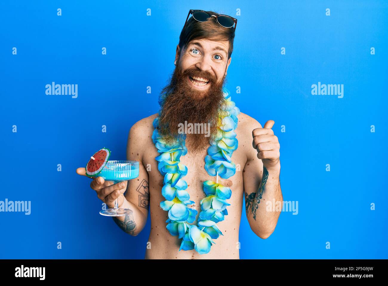 Redhead man with long beard wearing swimsuit drinking tropical cocktail ...