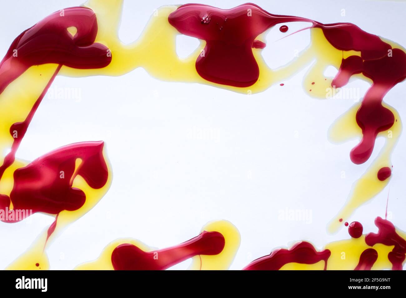 light gray background with a frame of spilled honey and cherry syrup ...