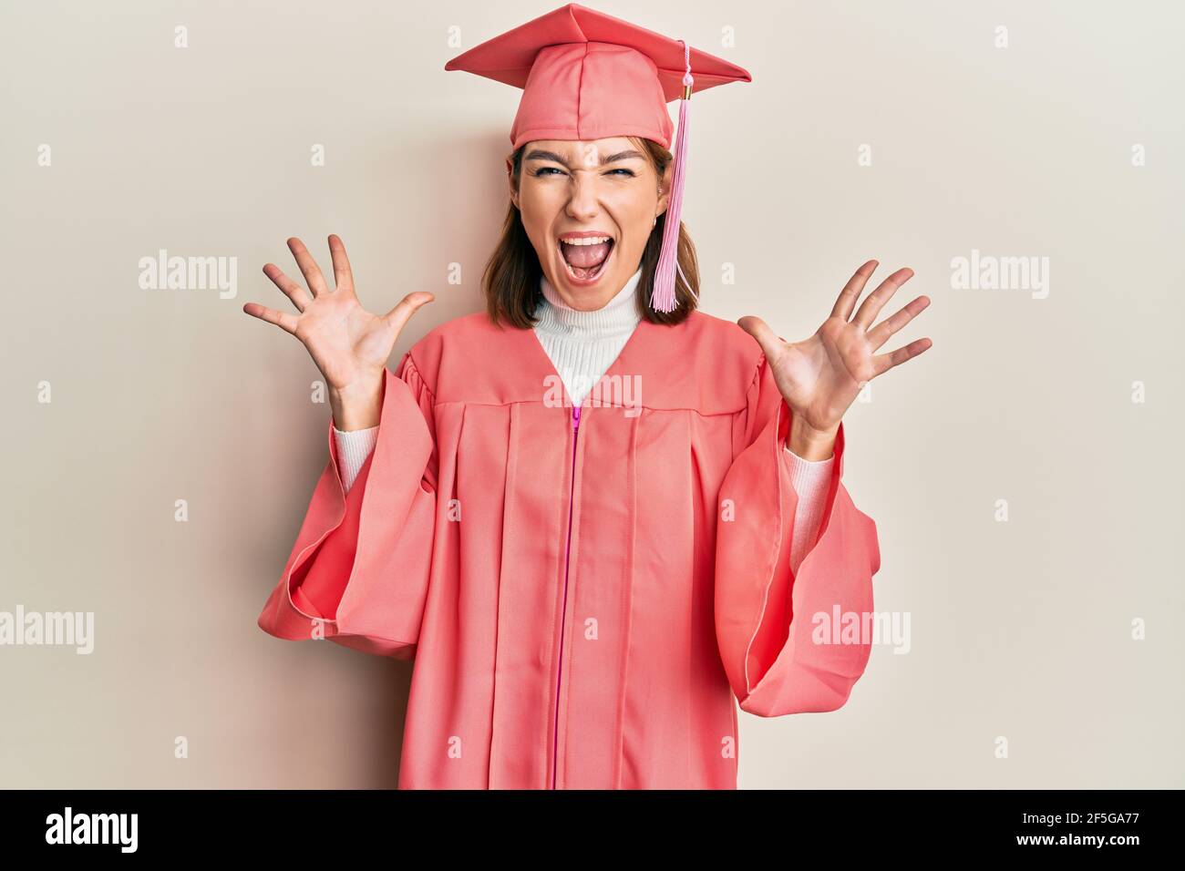 Young caucasian woman wearing graduation cap and ceremony robe ...