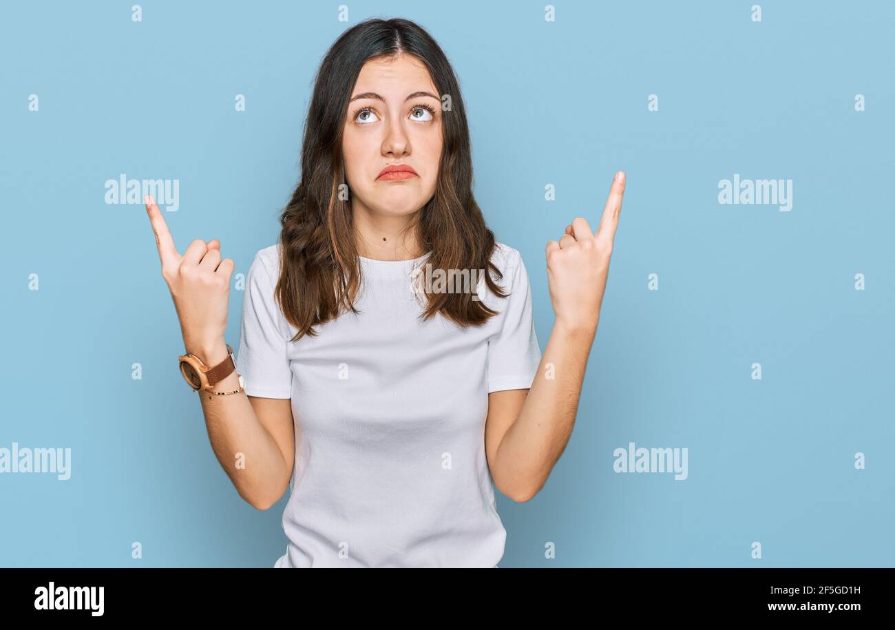 Young beautiful woman wearing casual white t shirt pointing up looking ...
