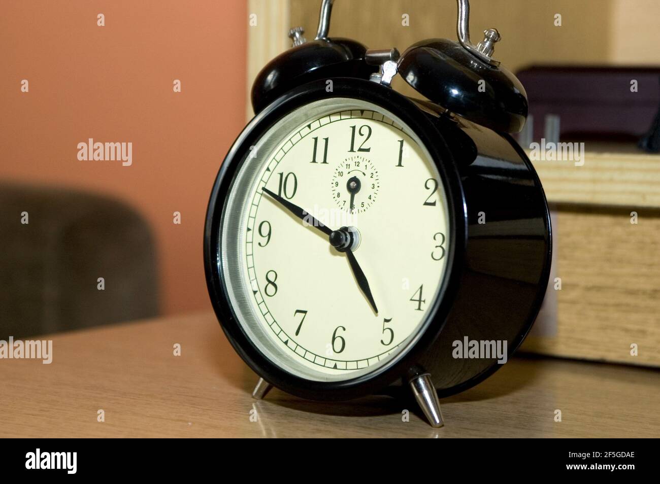 Old style alarm clock, solid clock, black color with white timeplate ...