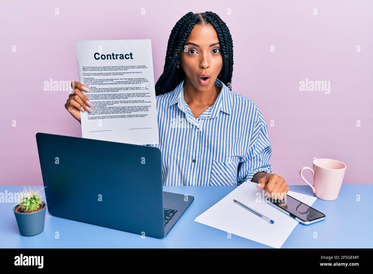 Beautiful hispanic woman at the office showing contract document scared ...