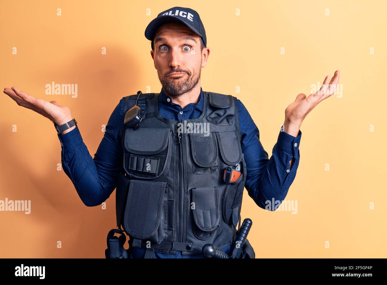 Young handsome policeman wearing police uniform and bulletprof over ...