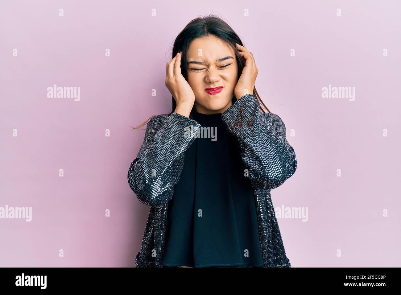 Young hispanic girl wearing party jacket suffering from headache ...
