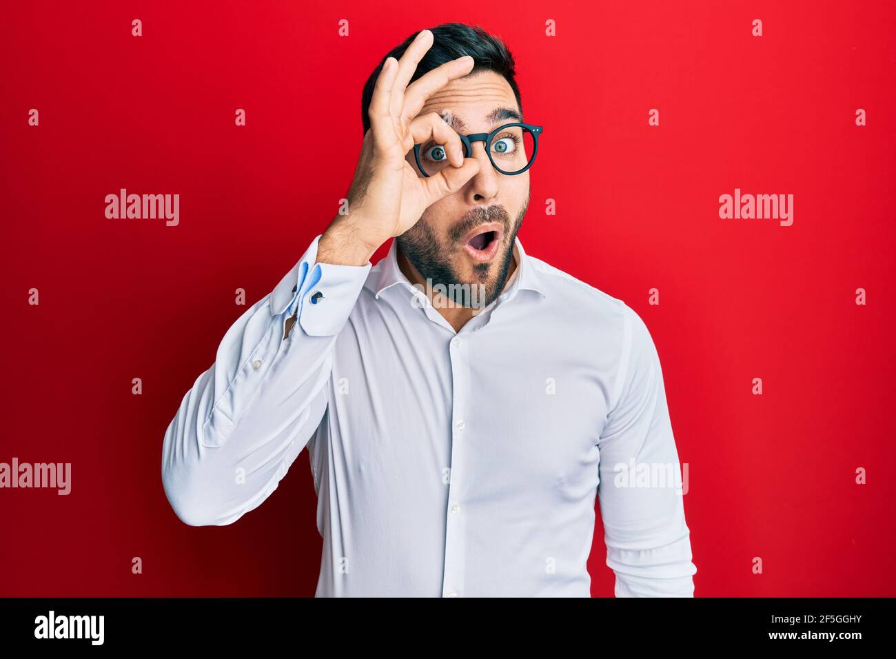 Young hispanic businessman wearing shirt and glasses doing ok gesture ...
