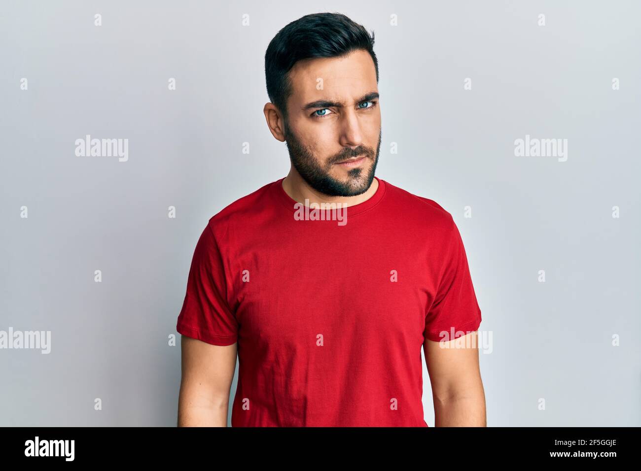 Young hispanic man wearing casual clothes skeptic and nervous, frowning ...