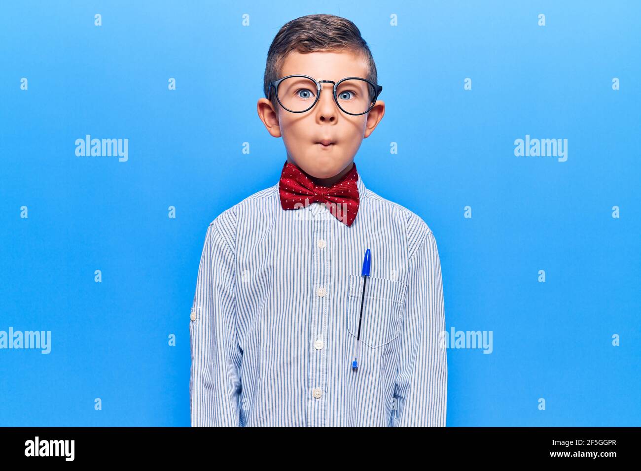 Cute blond kid wearing nerd bow tie and glasses making fish face with ...