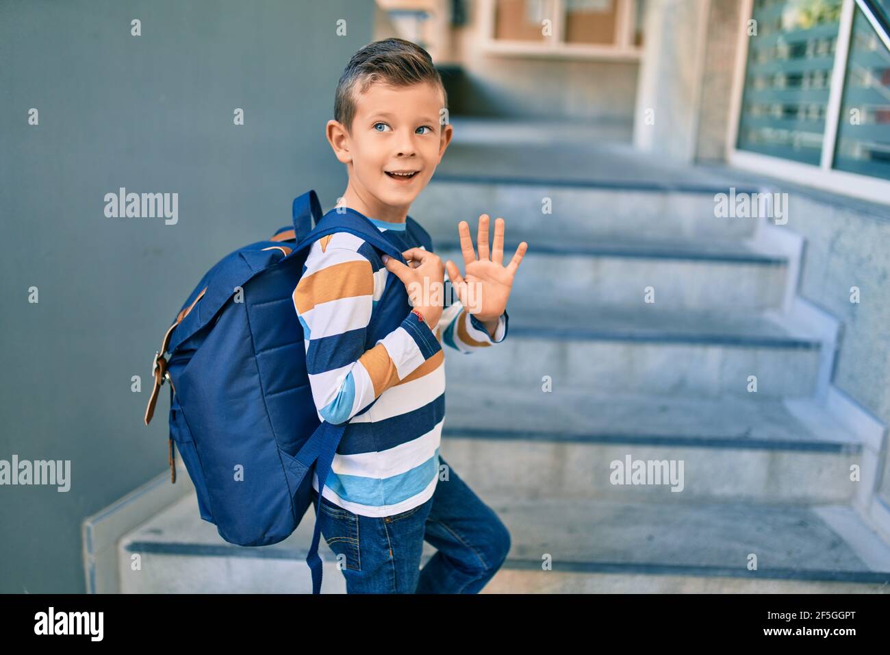 Adorable caucasian student boy smiling happy saying goodbye at the ...