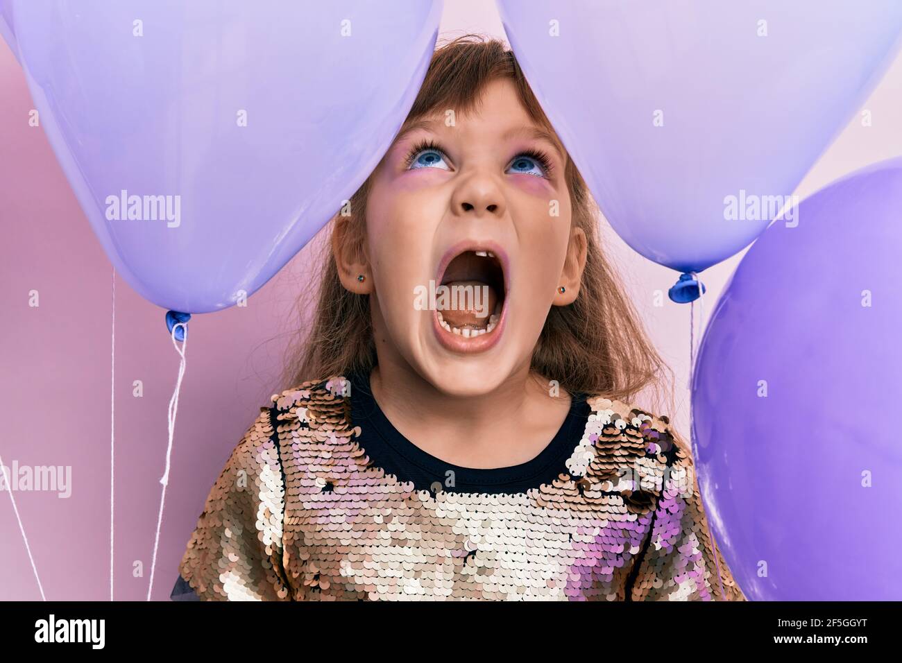Little caucasian girl kid holding balloons angry and mad screaming ...