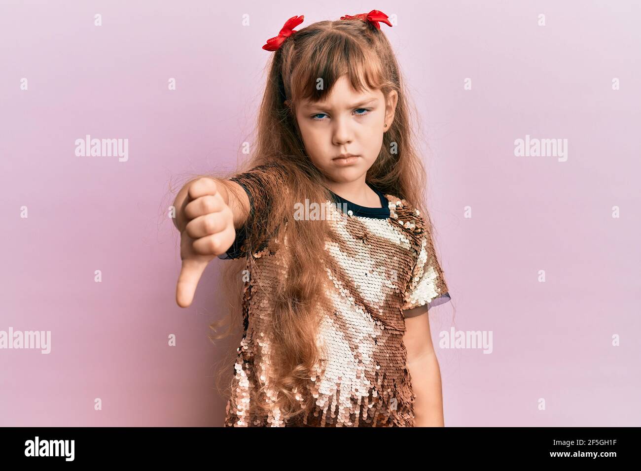 Little caucasian girl kid wearing festive sequins dress looking unhappy ...