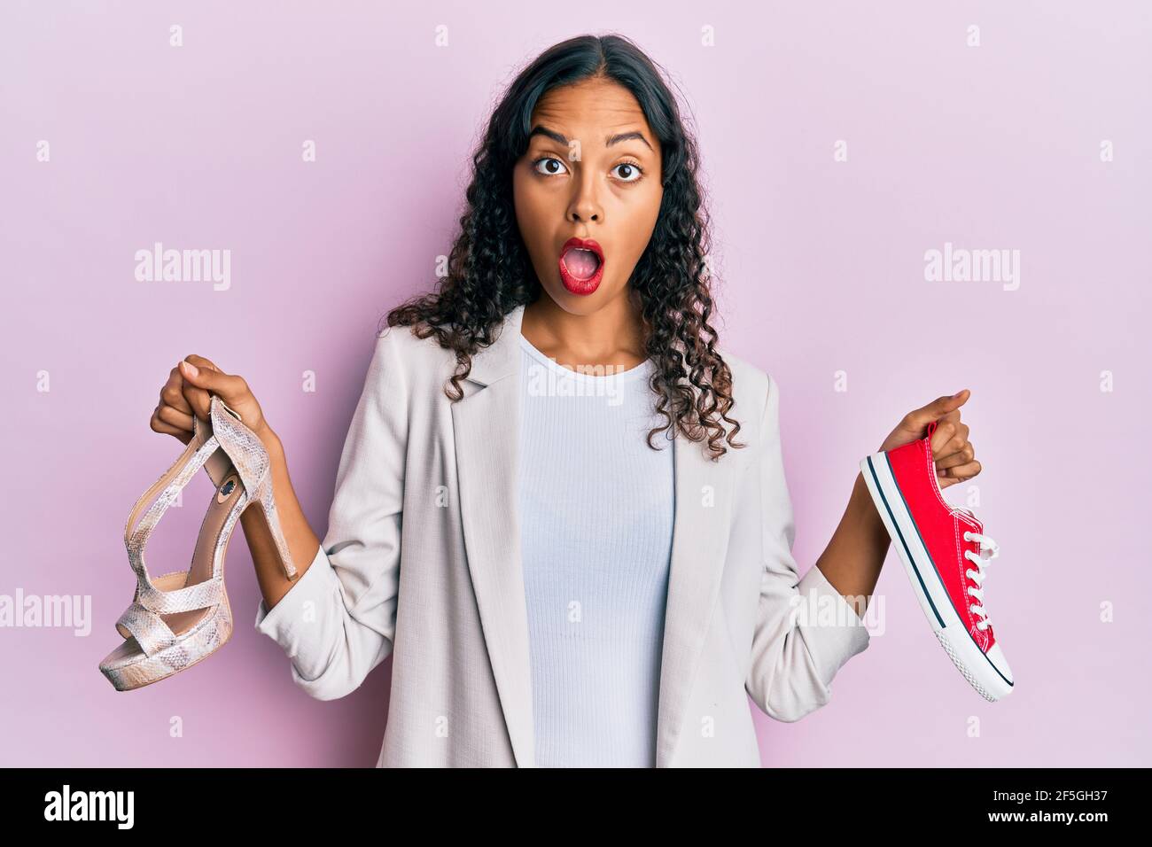Young african american girl choosing high heel shoes and sneakers in ...