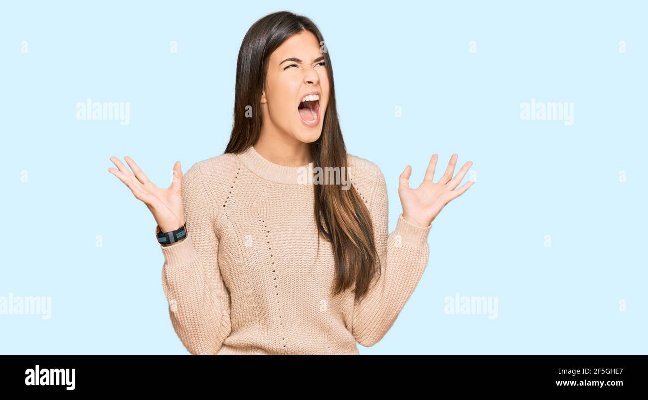 Young brunette woman wearing casual winter sweater crazy and mad ...