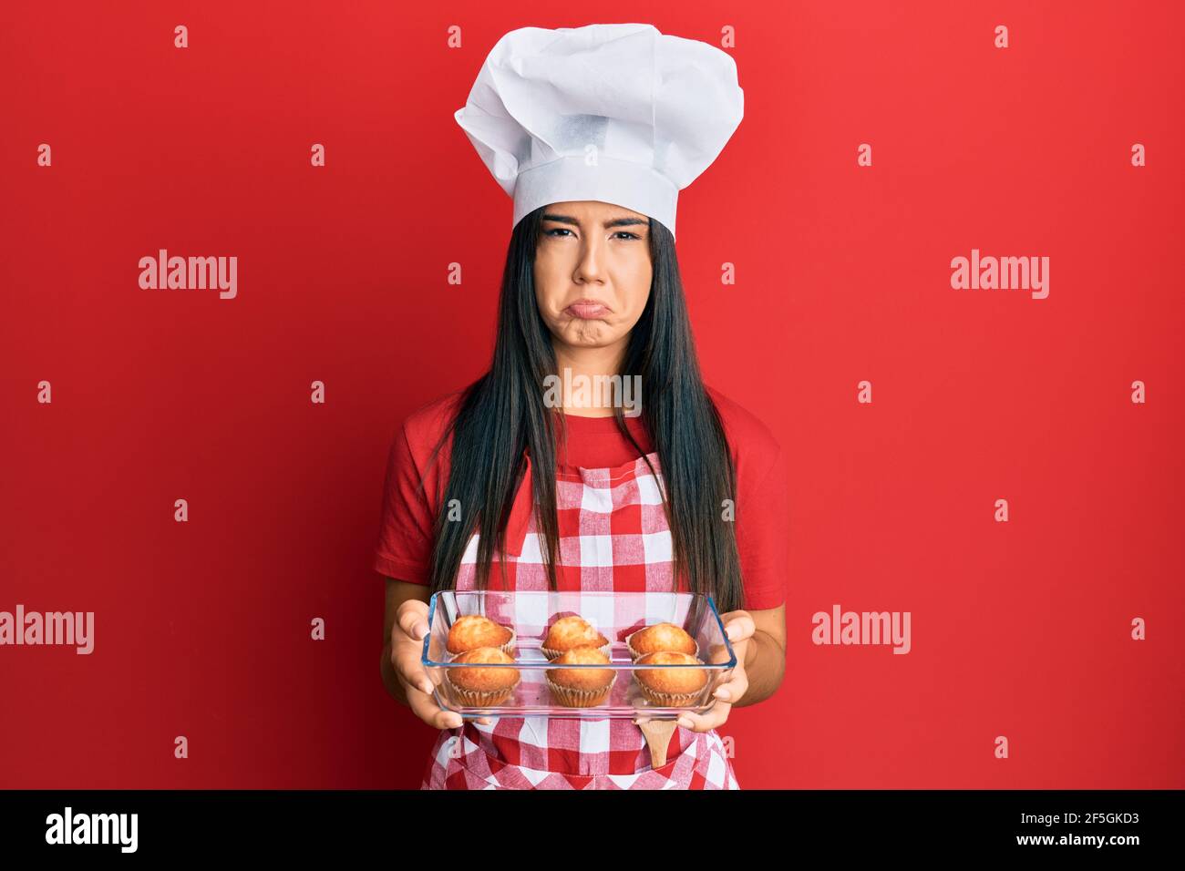 Young beautiful hispanic girl wearing baker apron making homemade ...