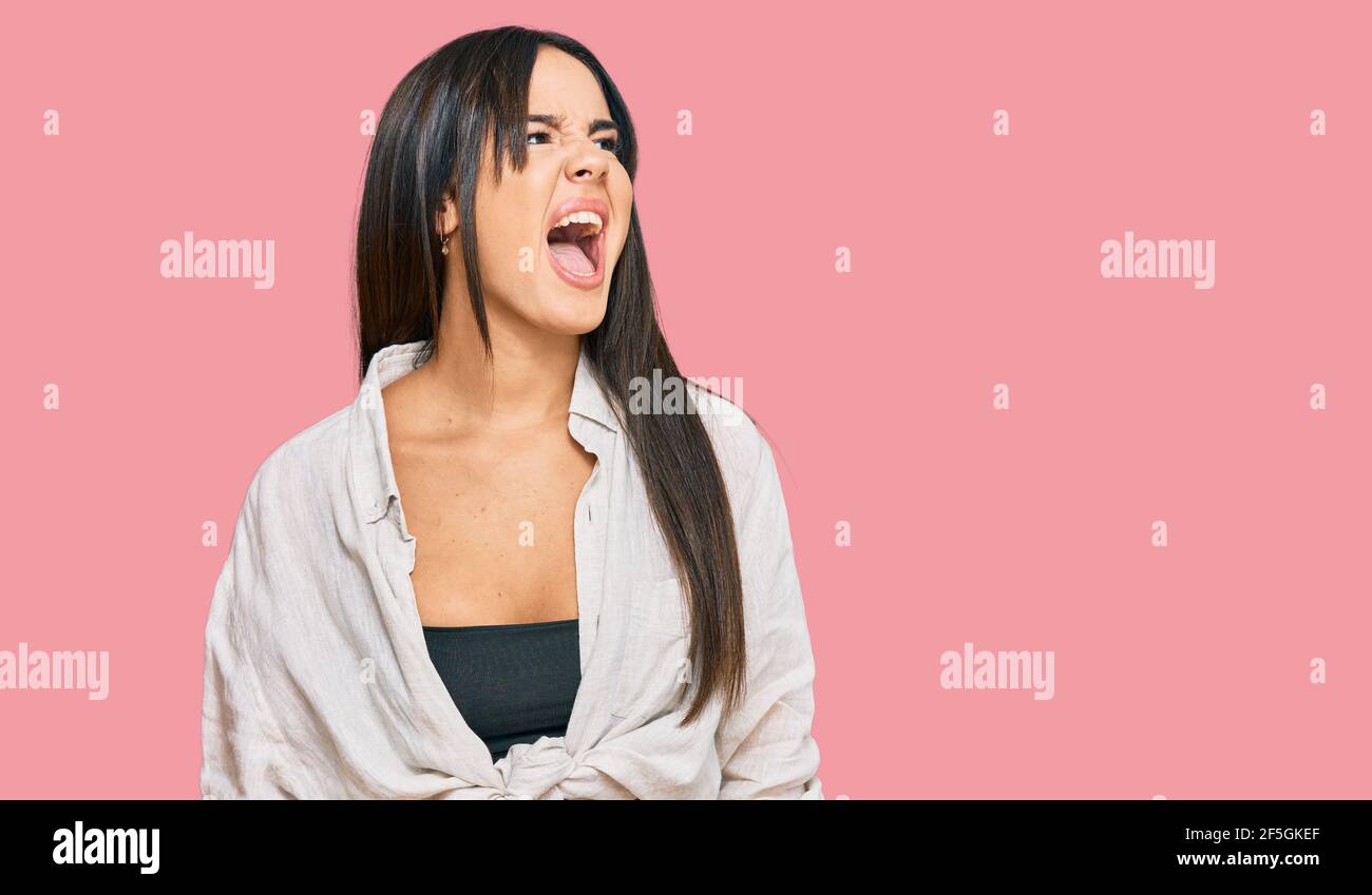 Young beautiful hispanic girl wearing casual clothes angry and mad ...