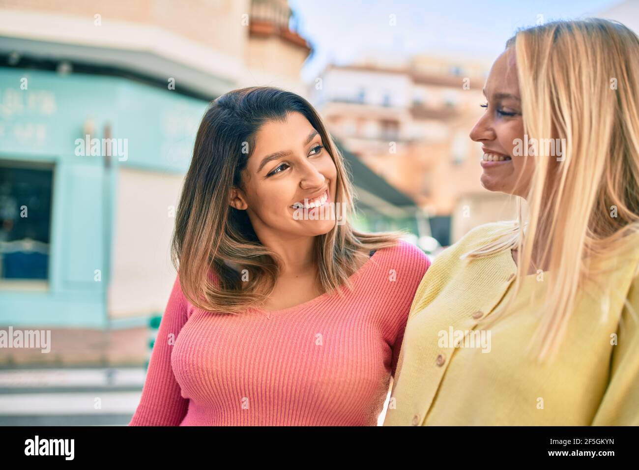 Two beautiful and young girl friends together having fun at the city ...
