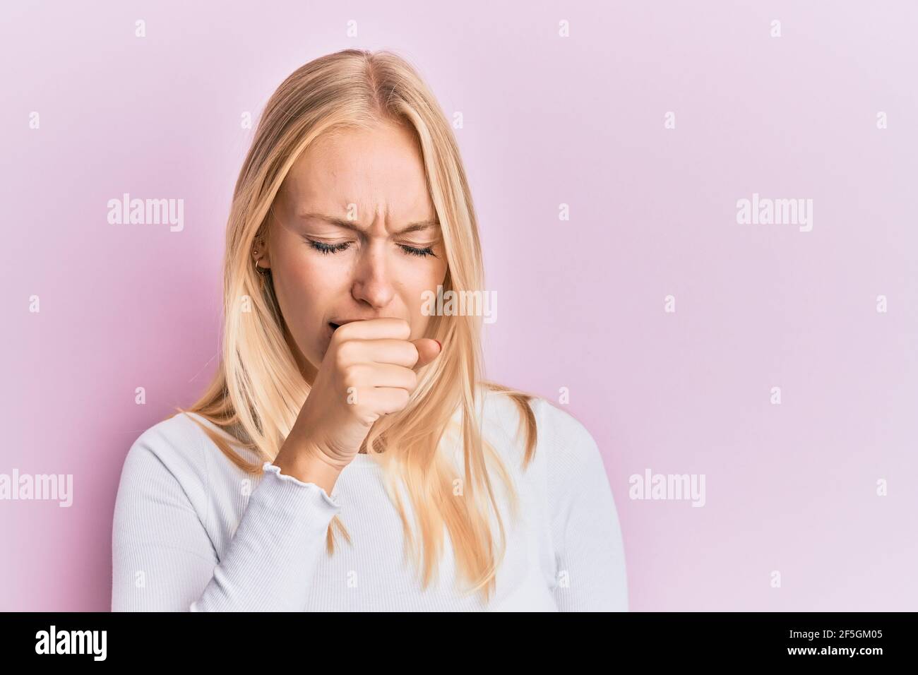 Young blonde girl wearing casual clothes feeling unwell and coughing as ...