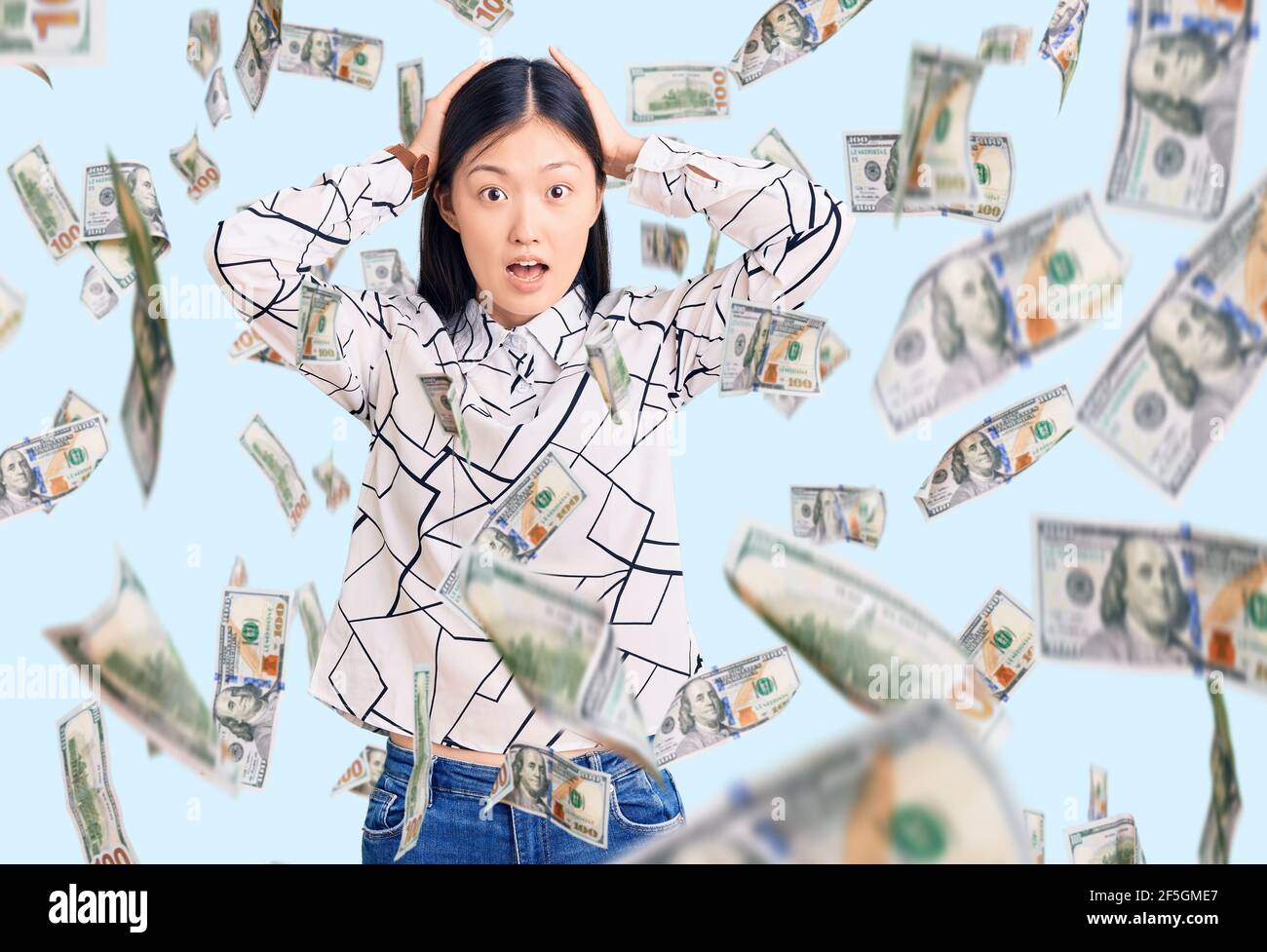 Young beautiful chinese woman wearing casual shirt crazy and scared ...