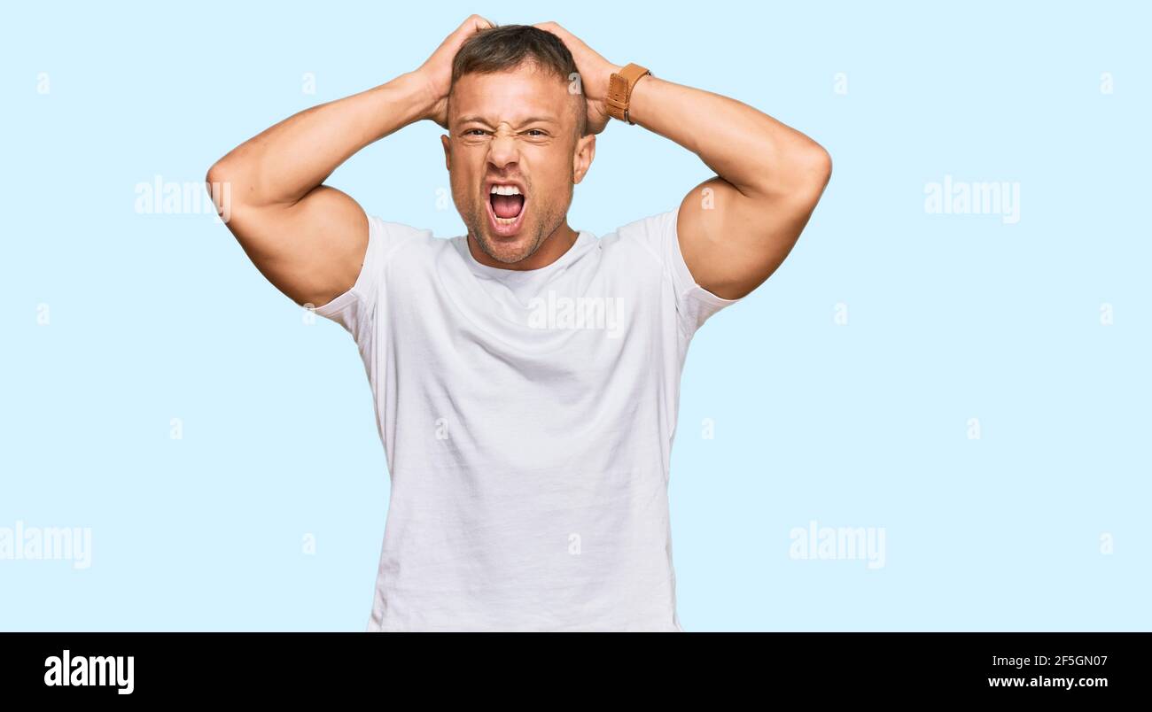 Handsome muscle man wearing casual white tshirt crazy and scared with ...