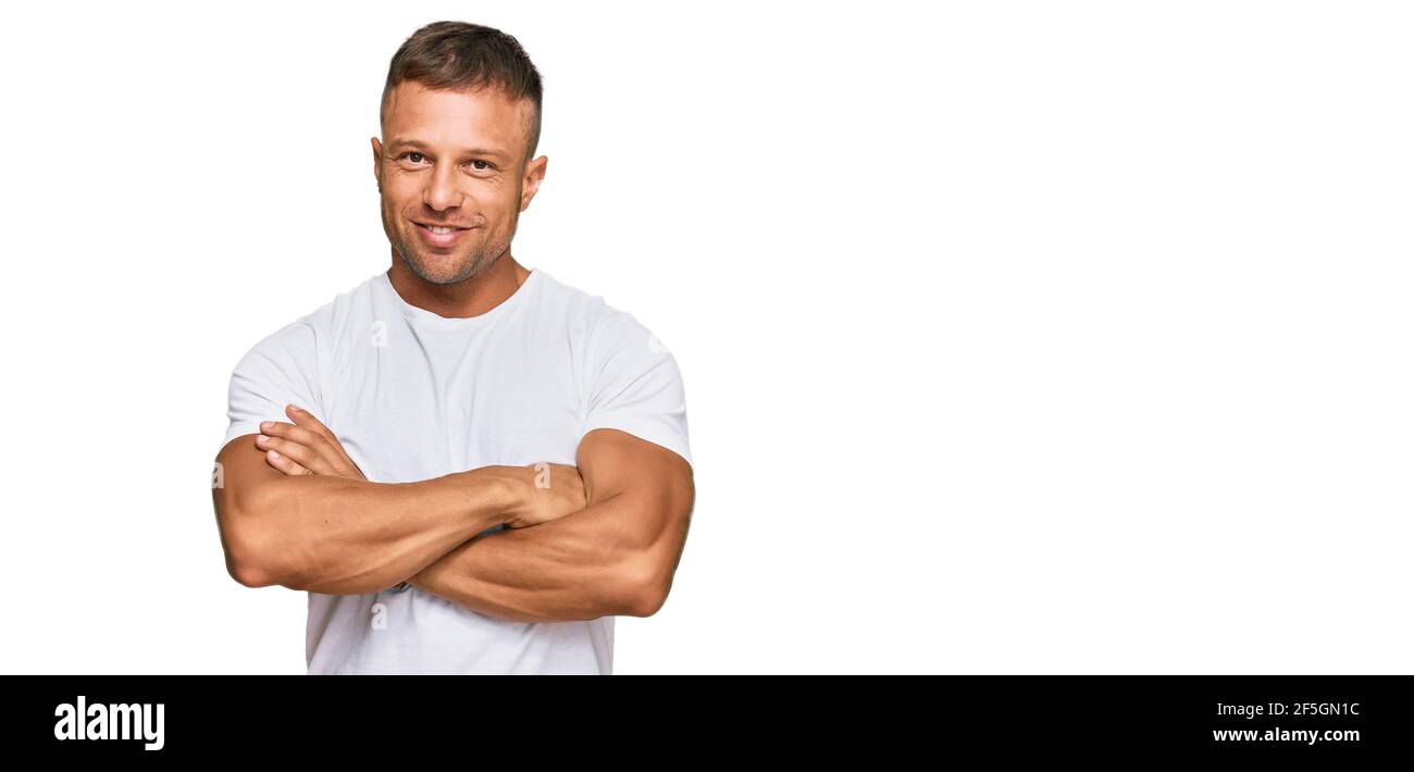 Handsome muscle man wearing casual white tshirt happy face smiling with ...