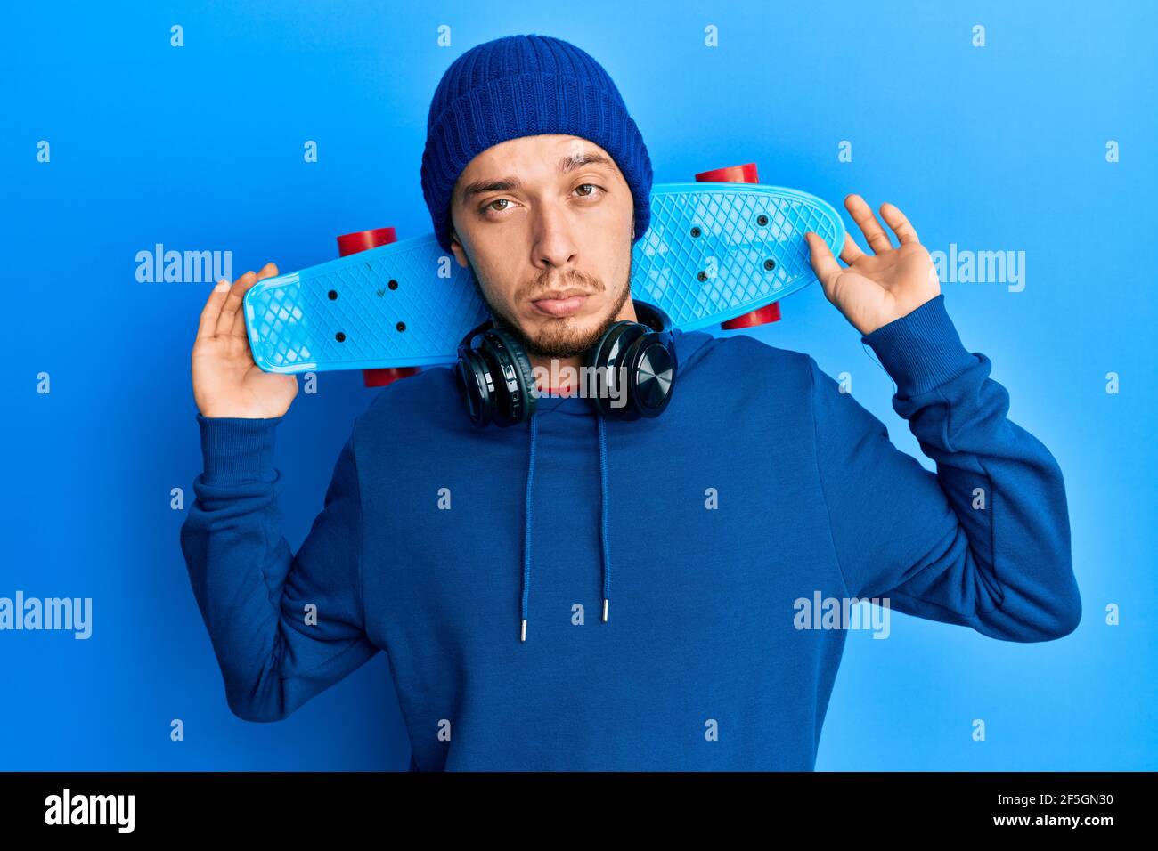 Hispanic young man holding skate depressed and worry for distress ...