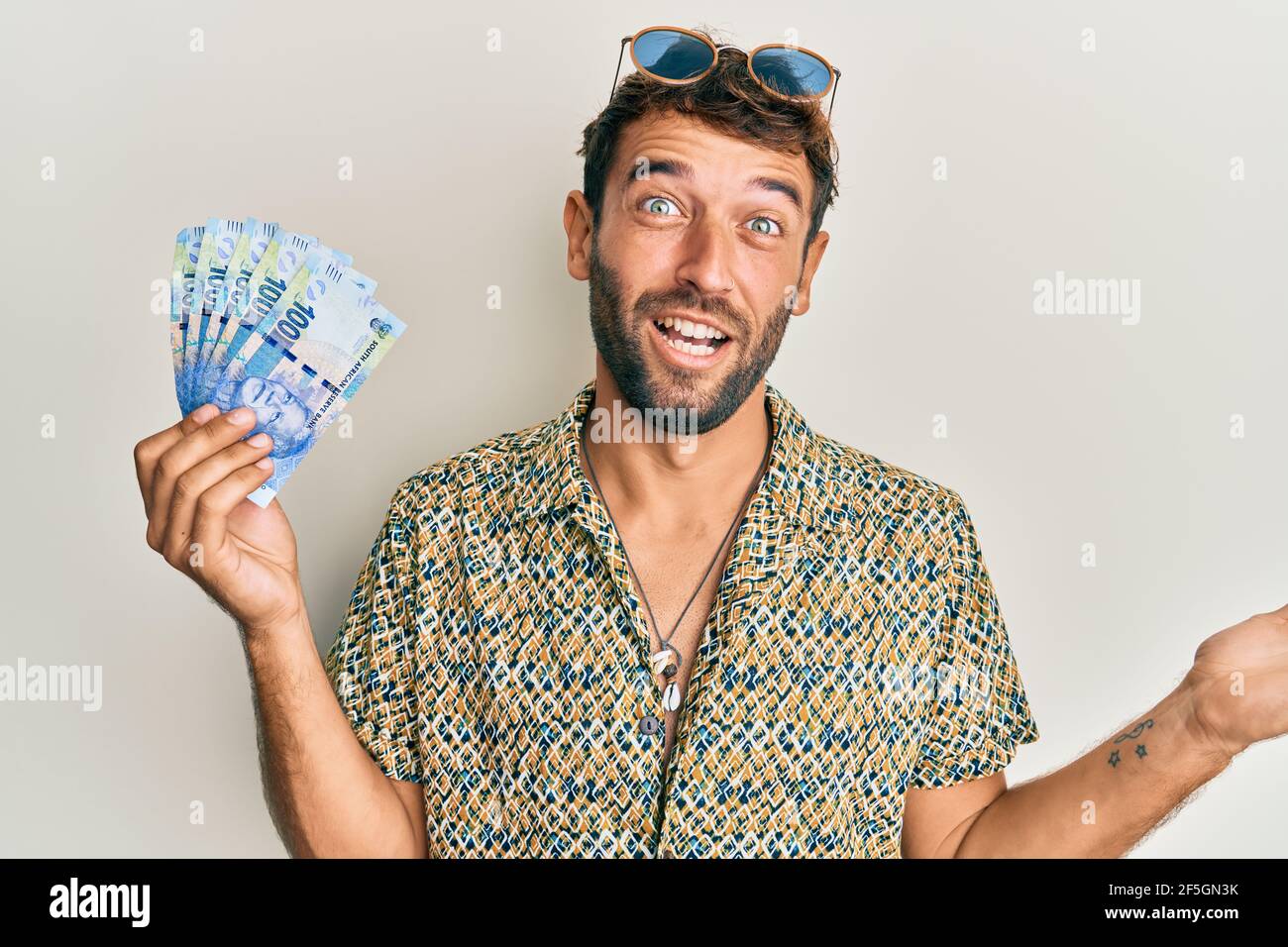 Handsome man with beard holding south african 100 rand banknotes ...